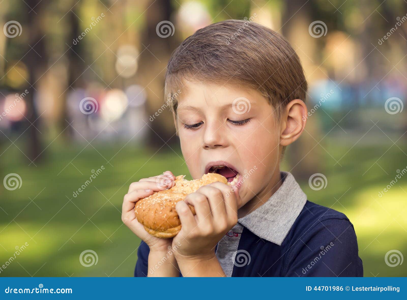 Boy eating a hamburger stock photo. Image of happy, cheerful - 44701986