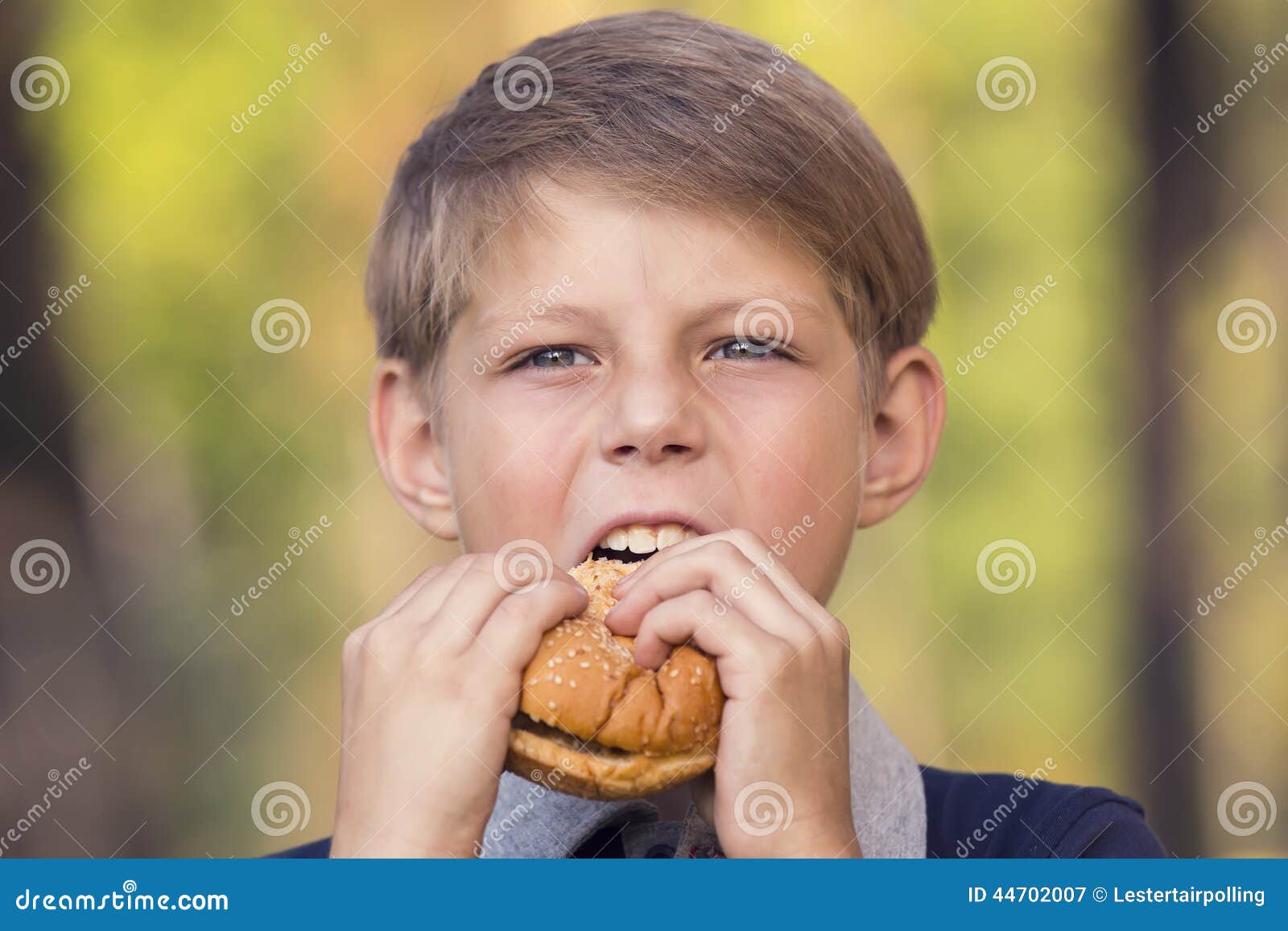 Boy eating a hamburger stock image. Image of bread, green - 44702007