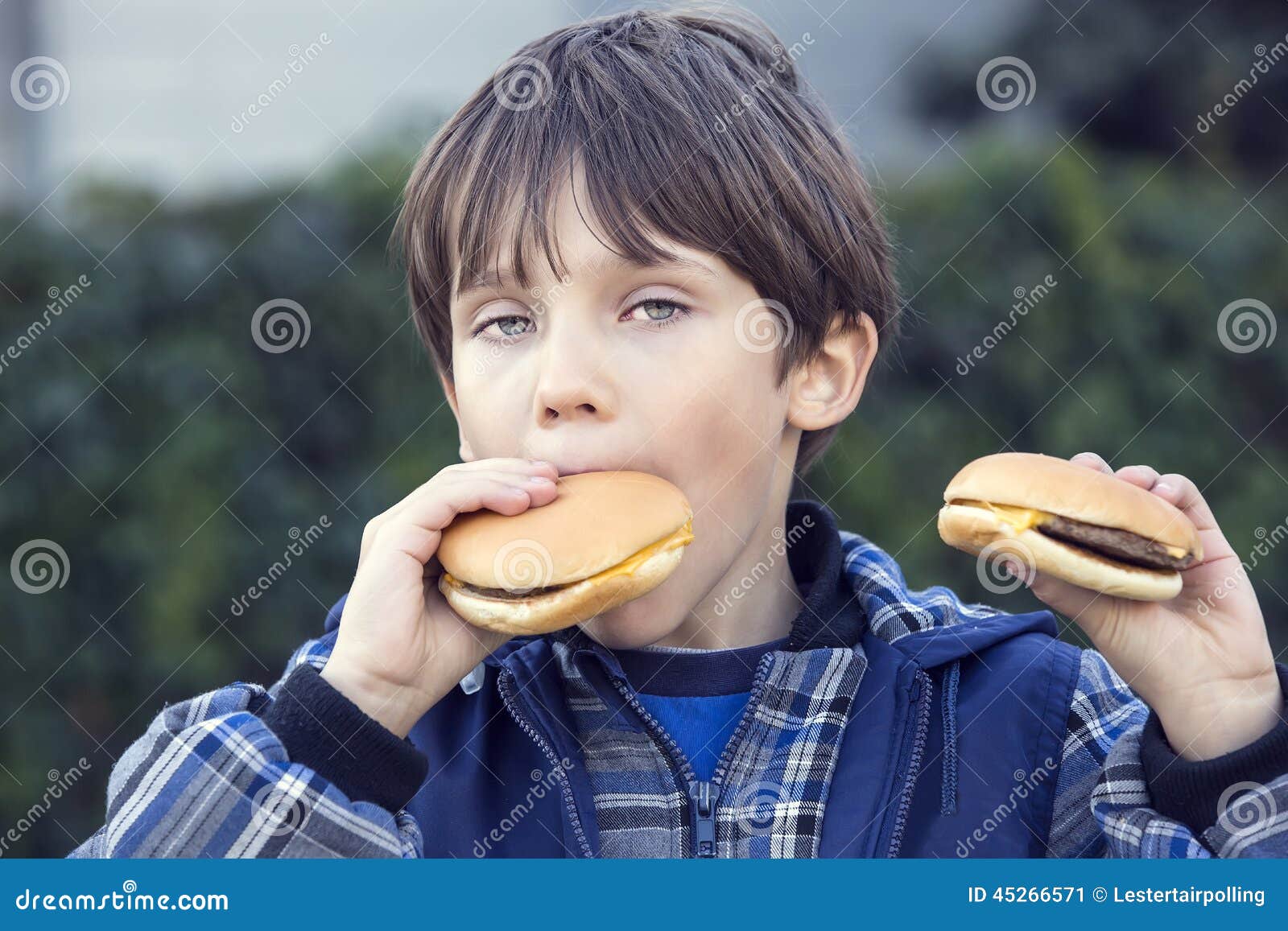 Boy eating a hamburger stock image. Image of green, male - 45266571