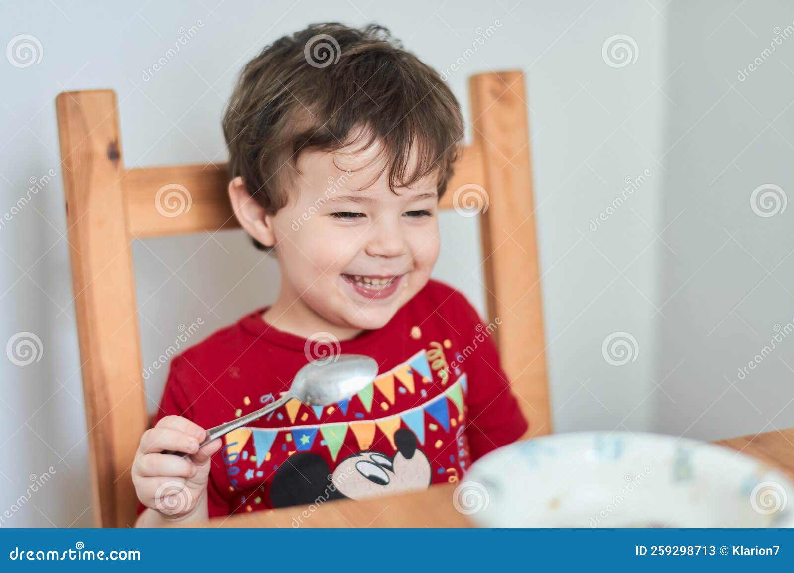 Young Boy Eating Breakfast at the Kitchen Table and Fooling Around ...
