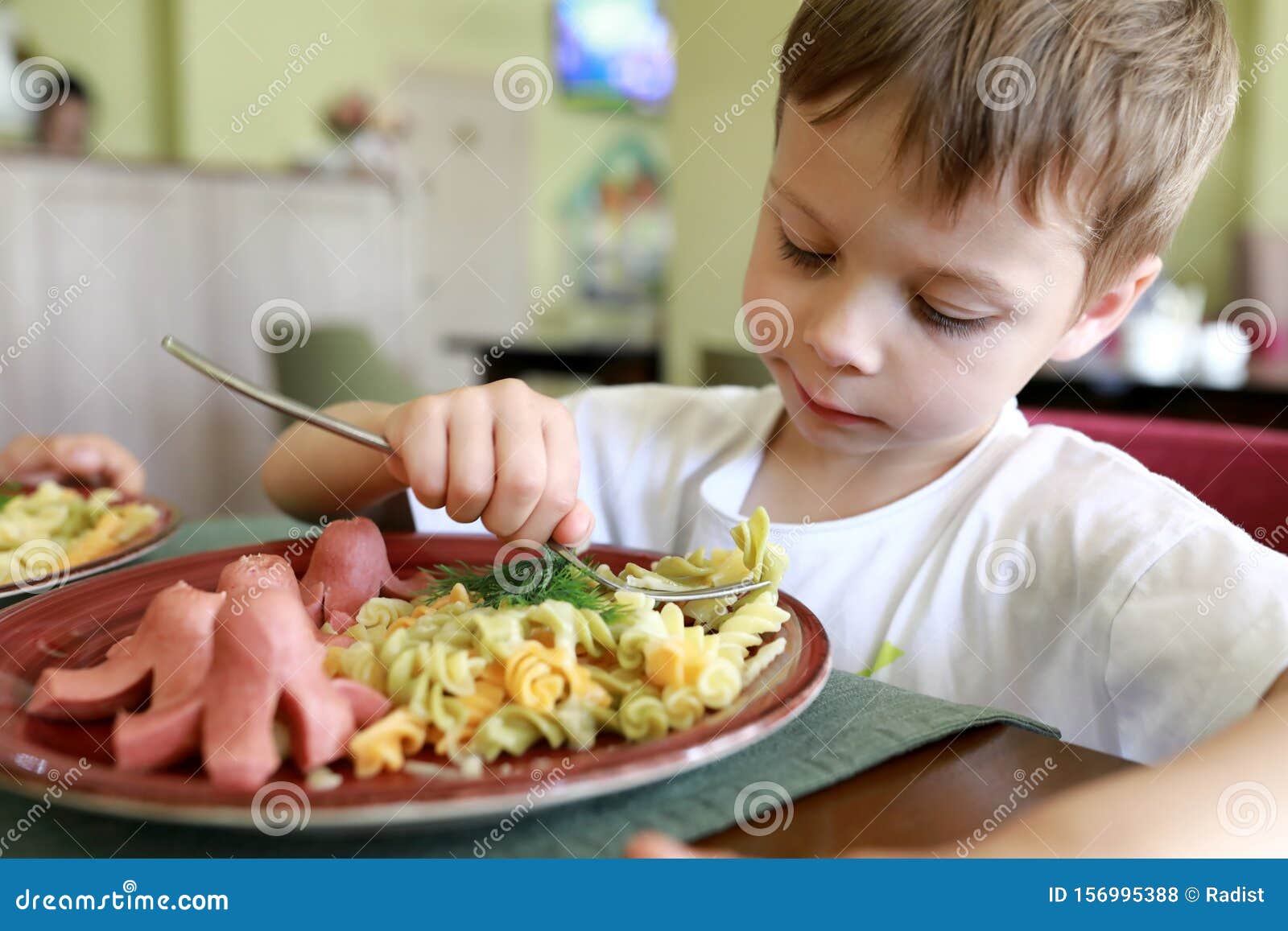 Boy Eating Pasta with Sausages Stock Photo - Image of hand, face: 156995388