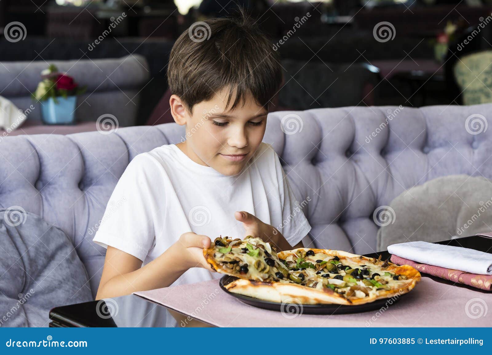 The boy is eating pizza stock image. Image of face, cafe - 97603885
