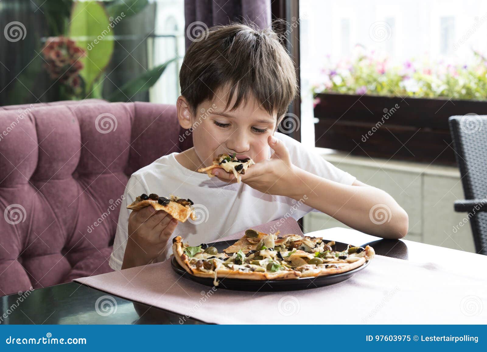 The boy is eating pizza stock image. Image of closeup - 97603975