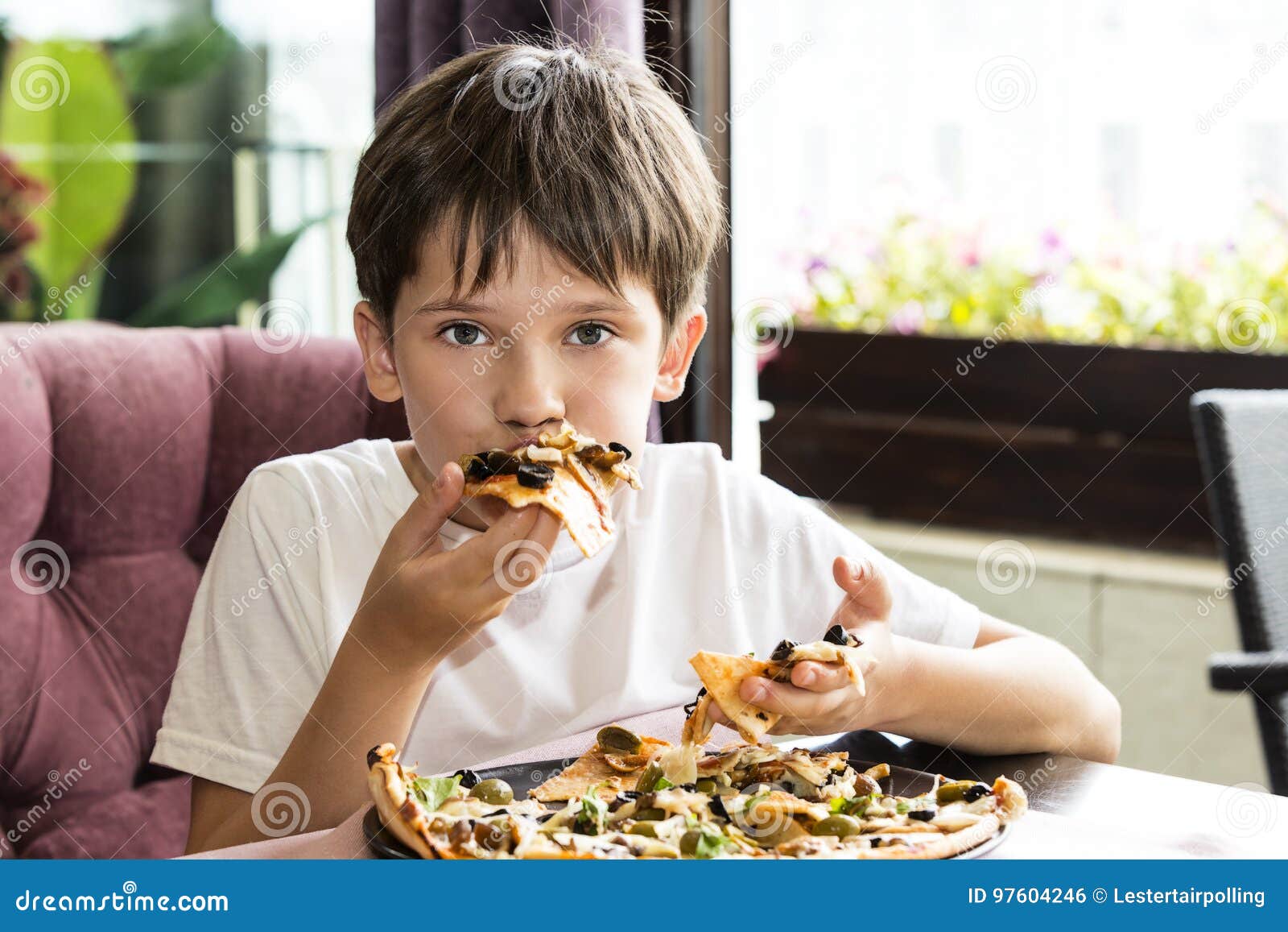 The boy is eating pizza stock photo. Image of caucasian - 97604246