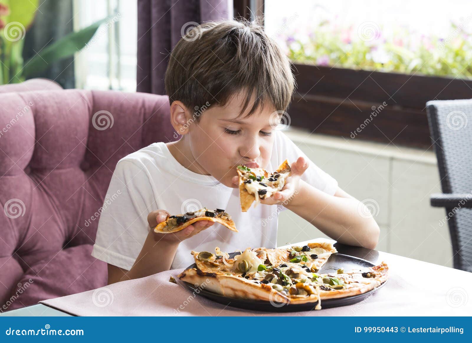 The boy is eating pizza stock image. Image of eyes, pizza - 99950443
