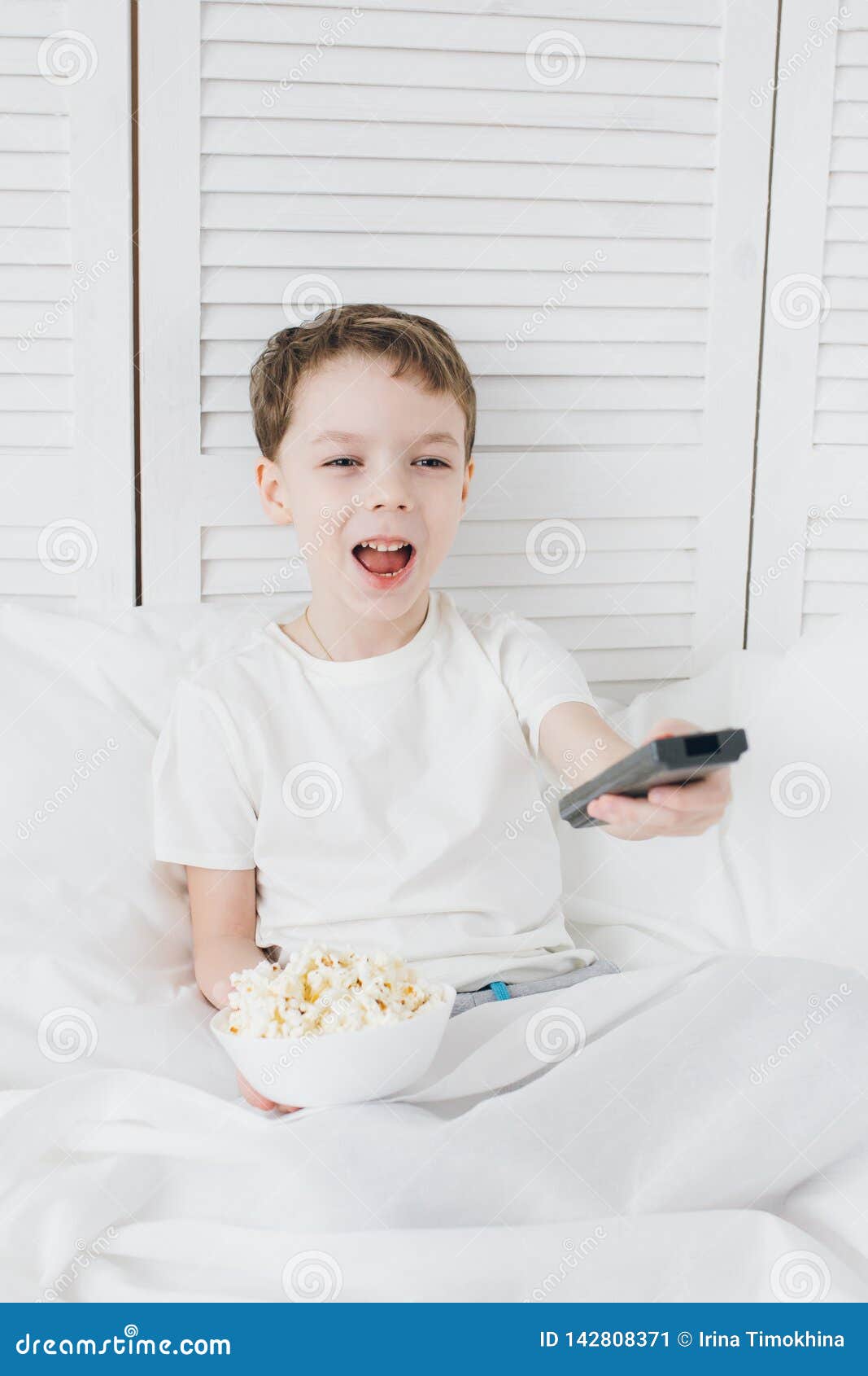 Boy Eating Popcorn Sitting in Bed and Watching TV Stock Image - Image ...