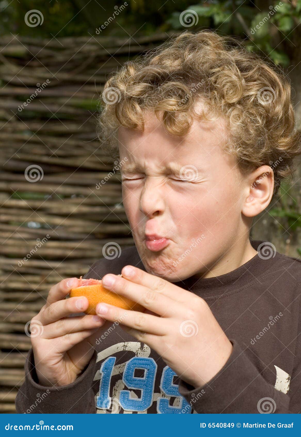 Boy eating Sour Fruit stock image. Image of gruesome, fruits - 6540849