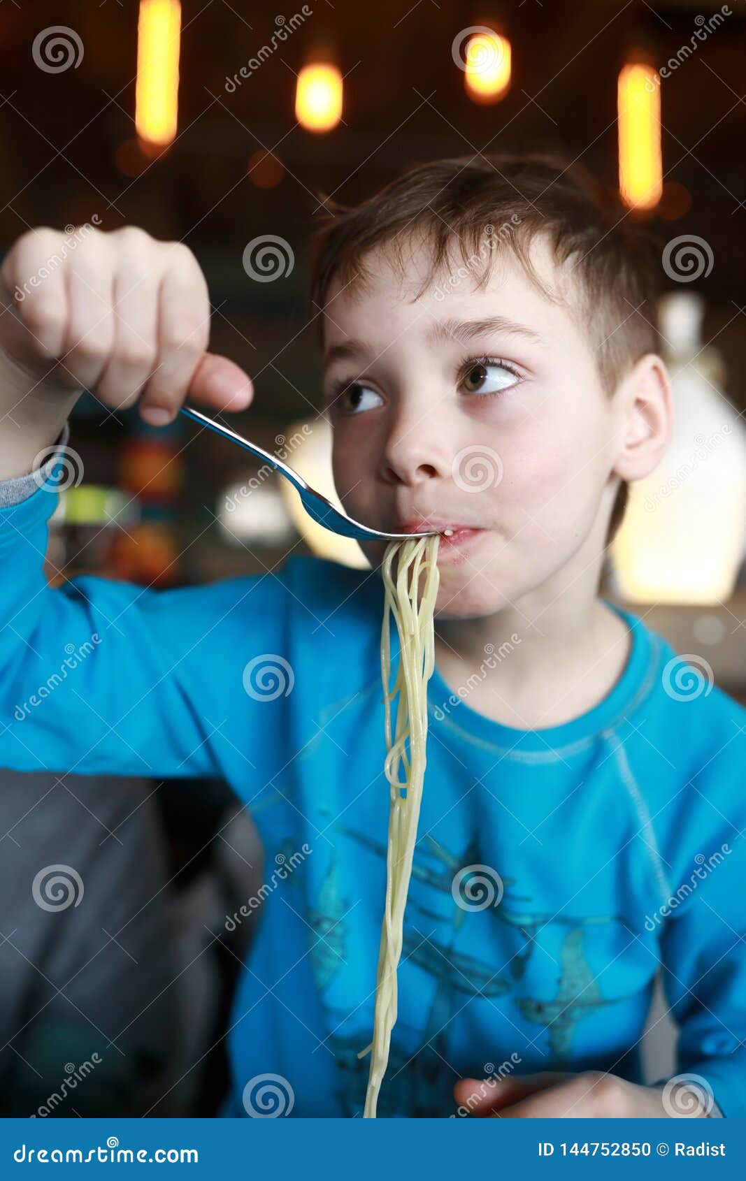 Boy eating spaghetti stock photo. Image of holding, dining - 144752850