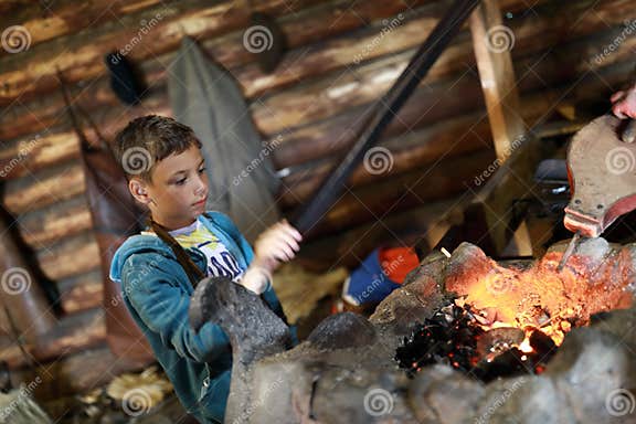 Boy fanning fire stock photo. Image of craftsmanship - 197772072