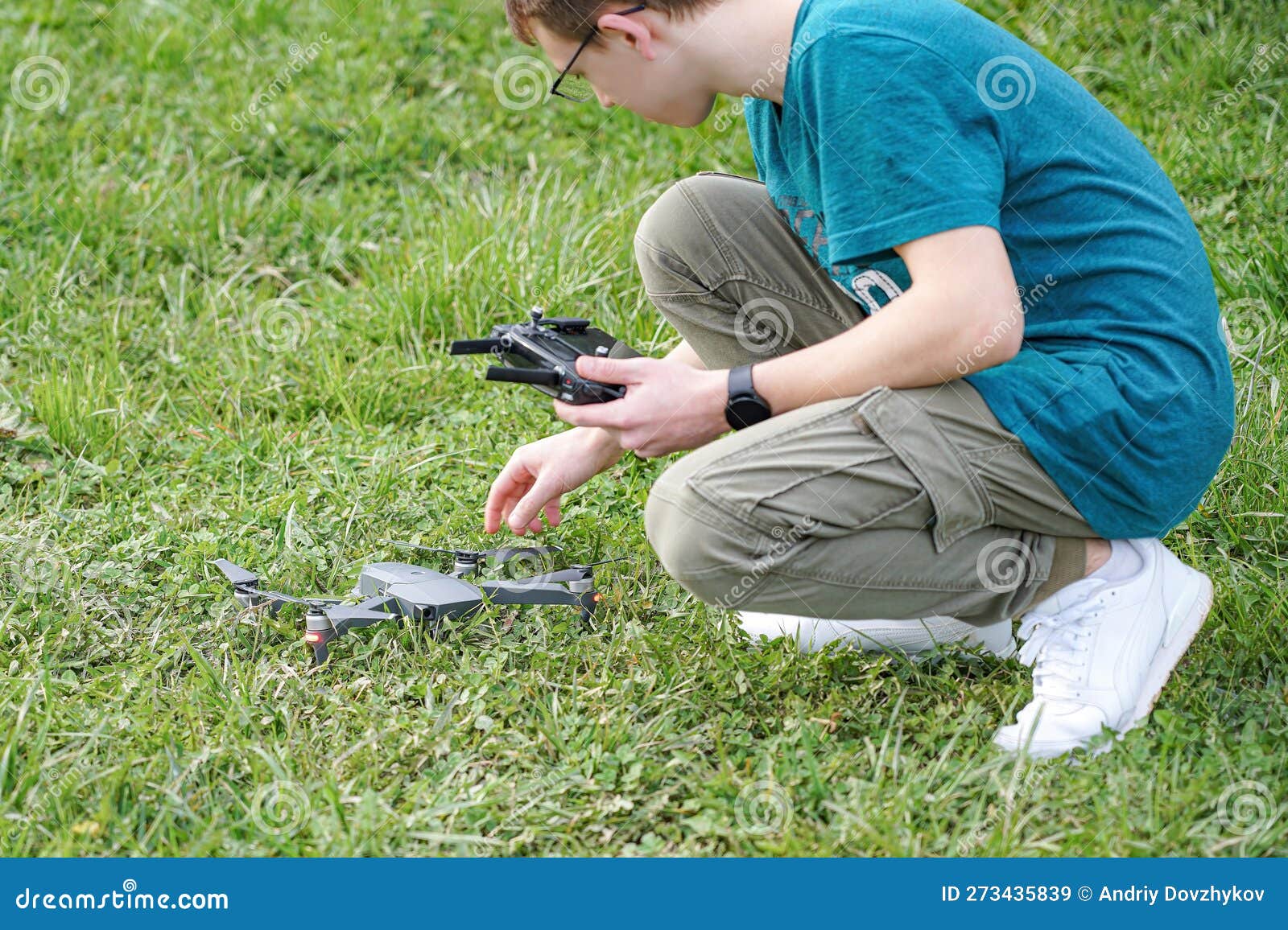 A Boy in a Field Launches a Quadcopter and Controls it from the Remote ...