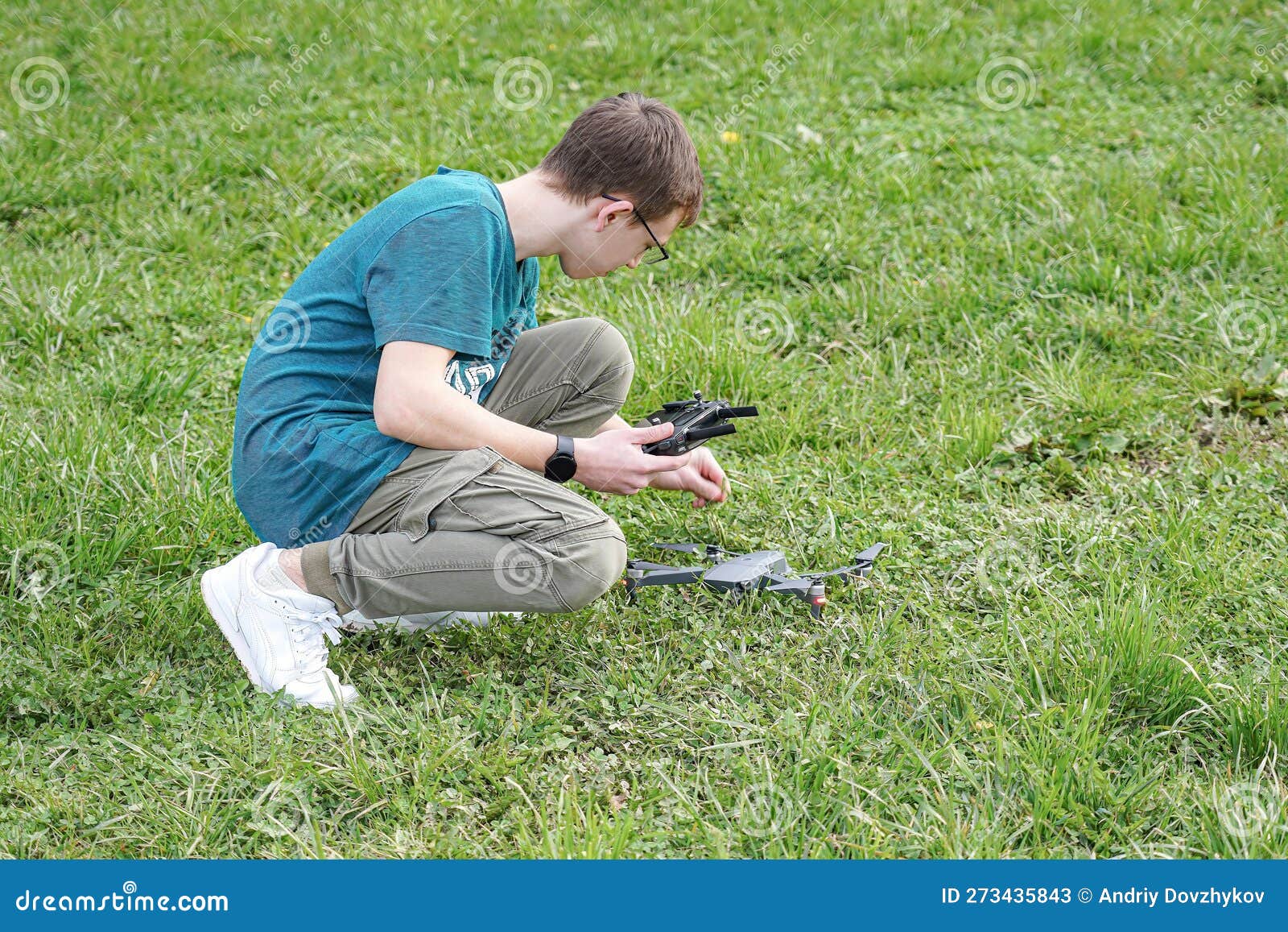 A Boy in a Field Launches a Quadcopter and Controls it from the Remote ...