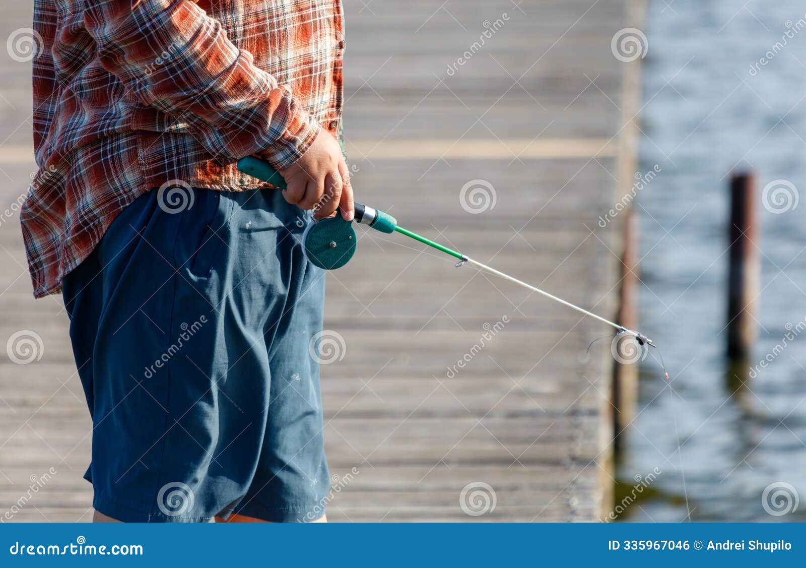 A Boy is Fishing with a Small Fishing Rod on a Pond Stock Photo - Image ...