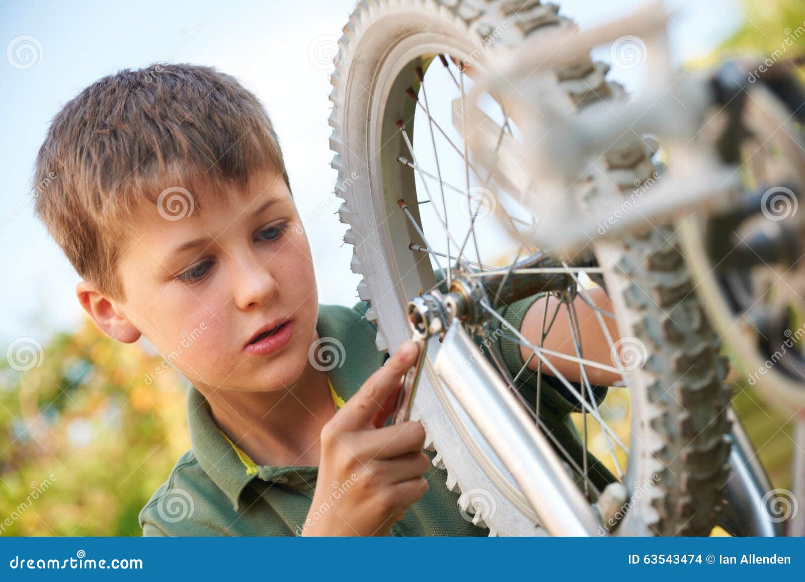 Boy Fixing Wheel of Bike stock photo. Image of caucasian - 63543474