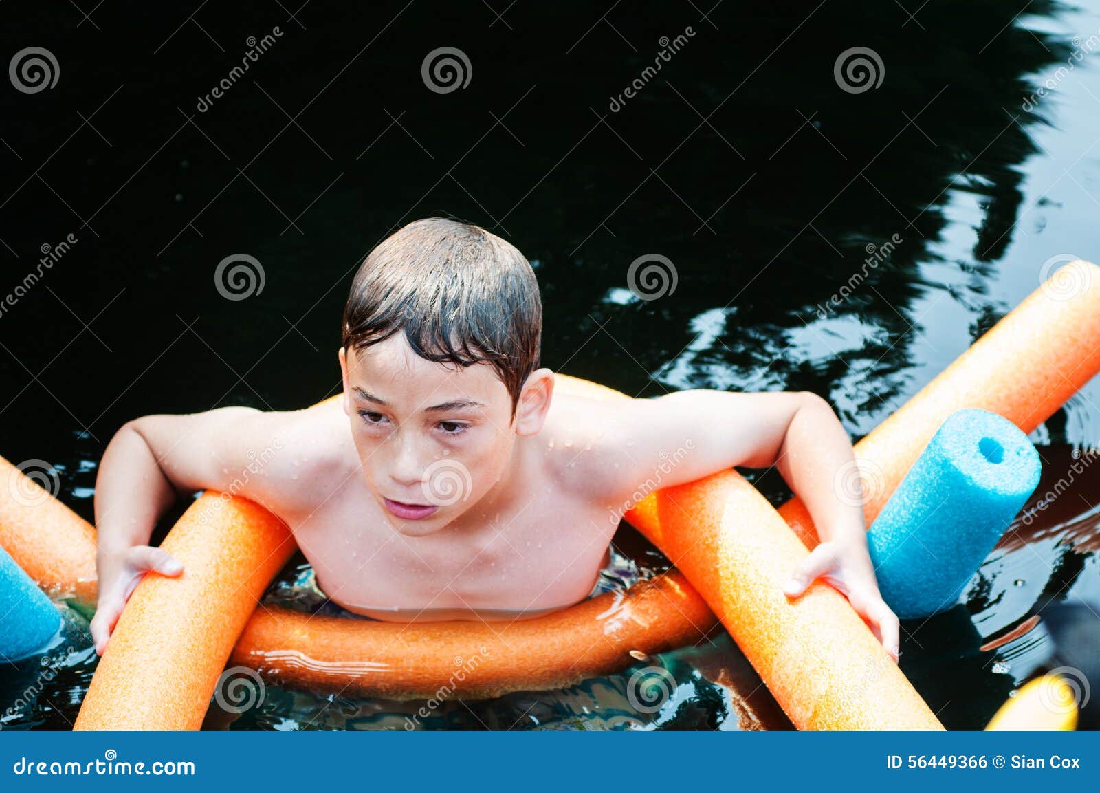 Boy floating in a lake stock photo. Image of noodles - 56449366