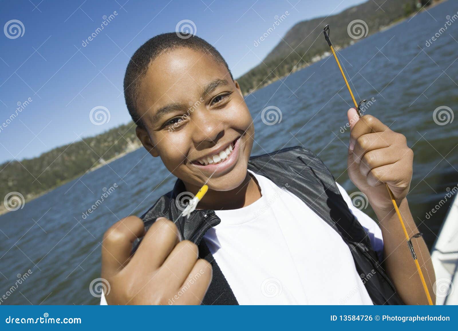 Boy fly fishing on lake stock photo. Image of looking - 13584726
