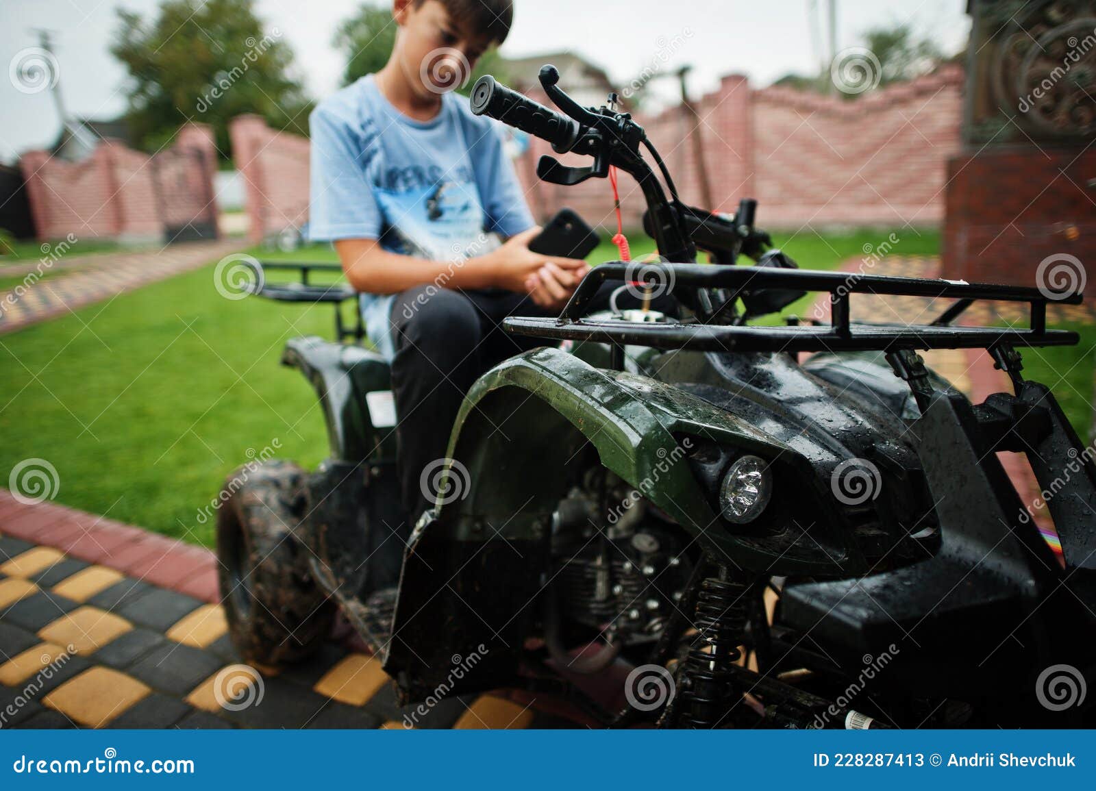 Boy in Four-wheller ATV Quad Bike with Mobile Phone Stock Image - Image ...