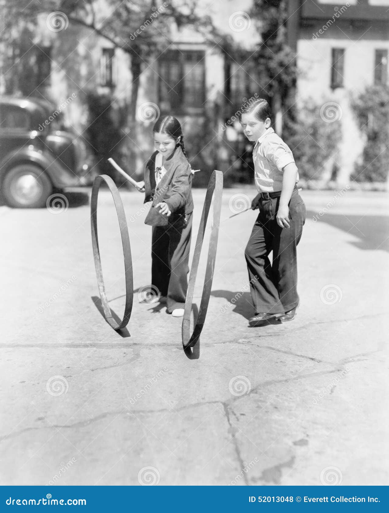 Boy and Girl Playing Hoop and Stick on a Sidewalk Stock Photo - Image ...