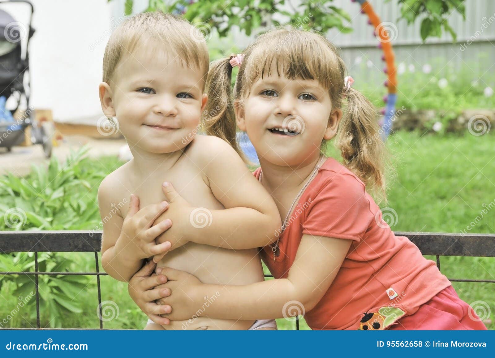 Boy And Girl Sitting Side By Side On The Bench, Hugging, Smiling ...