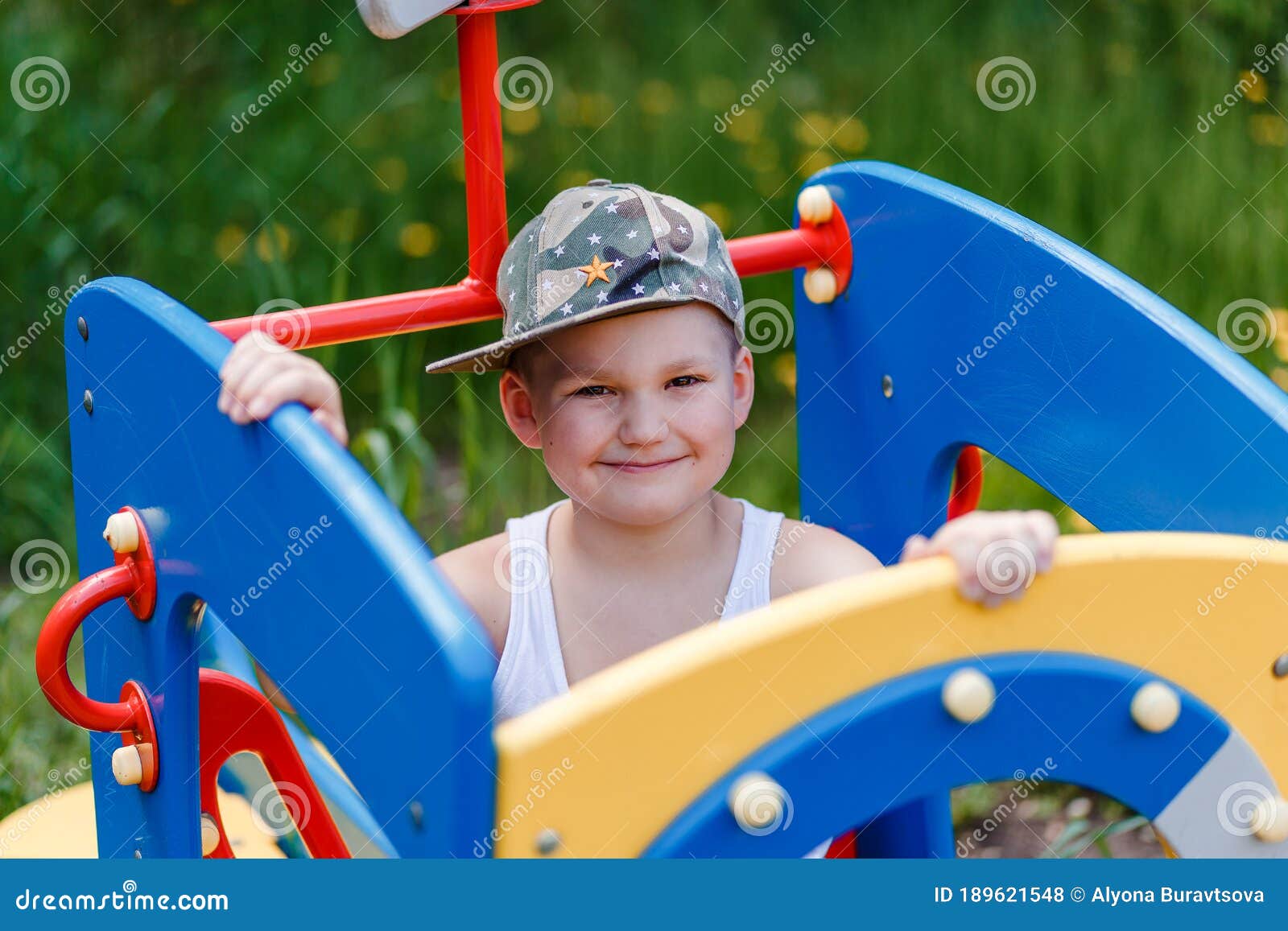 A Boy in a Green Summer Cap on the Playground Stock Photo - Image of ...
