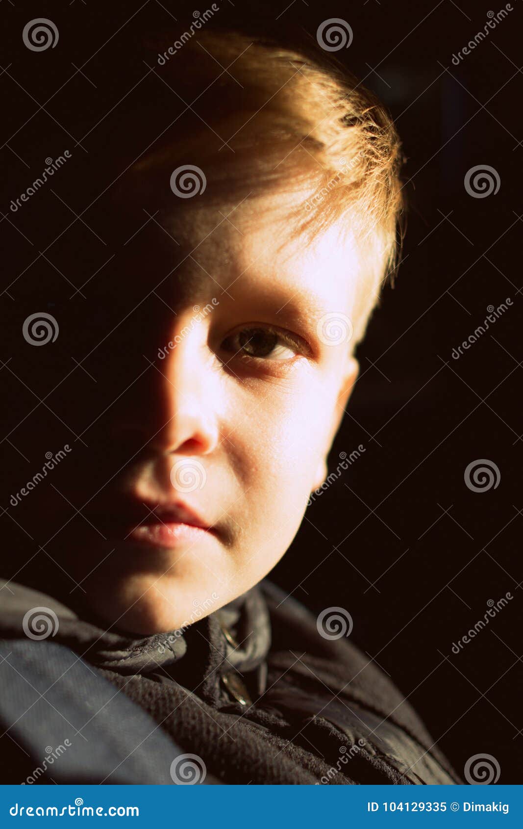 A Boy with Half-lighted Face Looking To the Camera. Boy`s Face in the ...