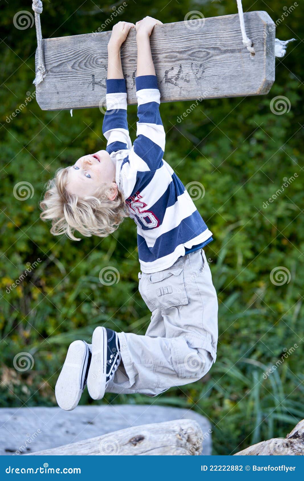 Boy Hanging from a Swing stock photo. Image of hanging - 22222882