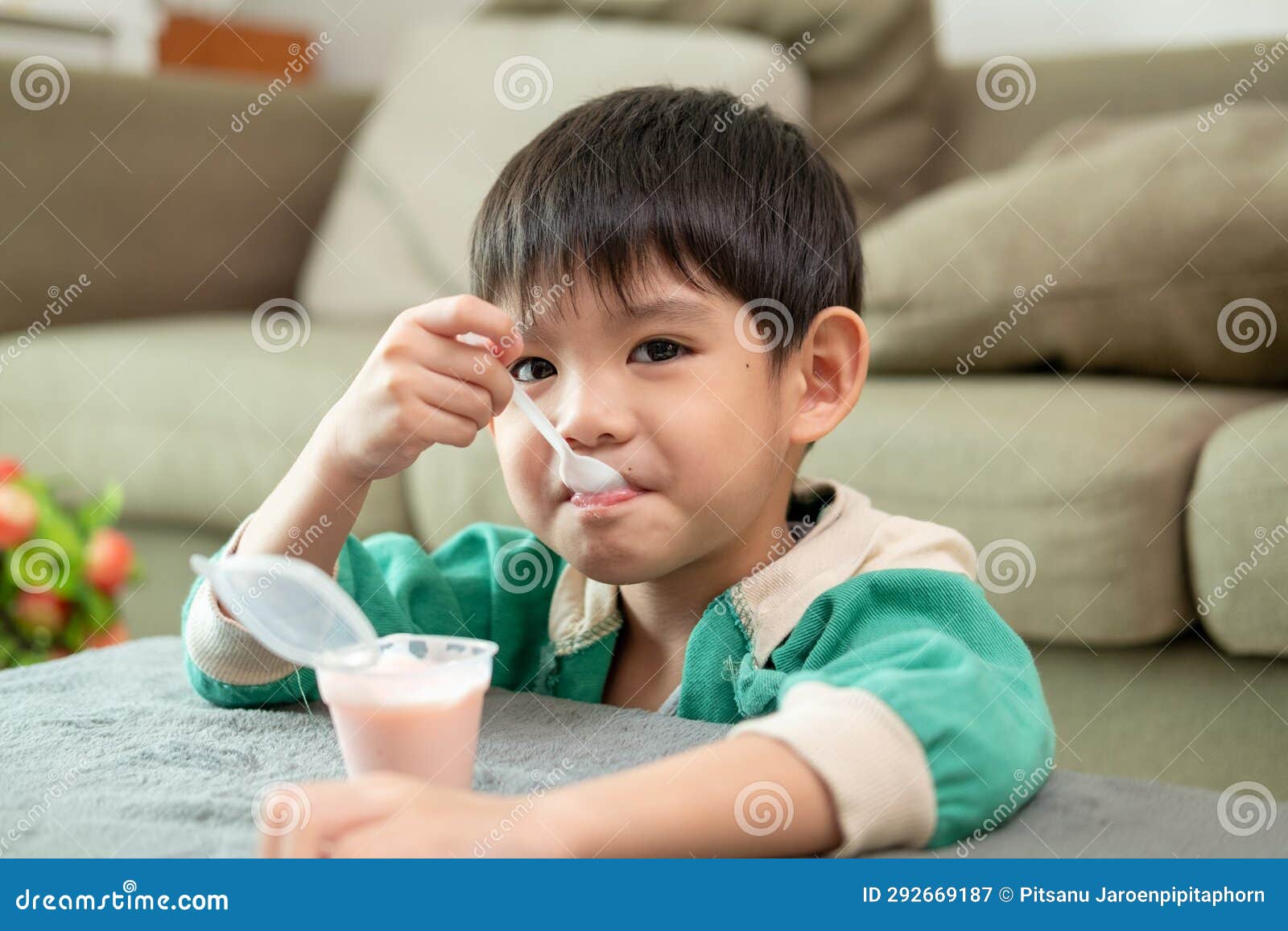 A Boy Happily Uses a Spoon To Scoop Up Yogurt Stock Image - Image of ...