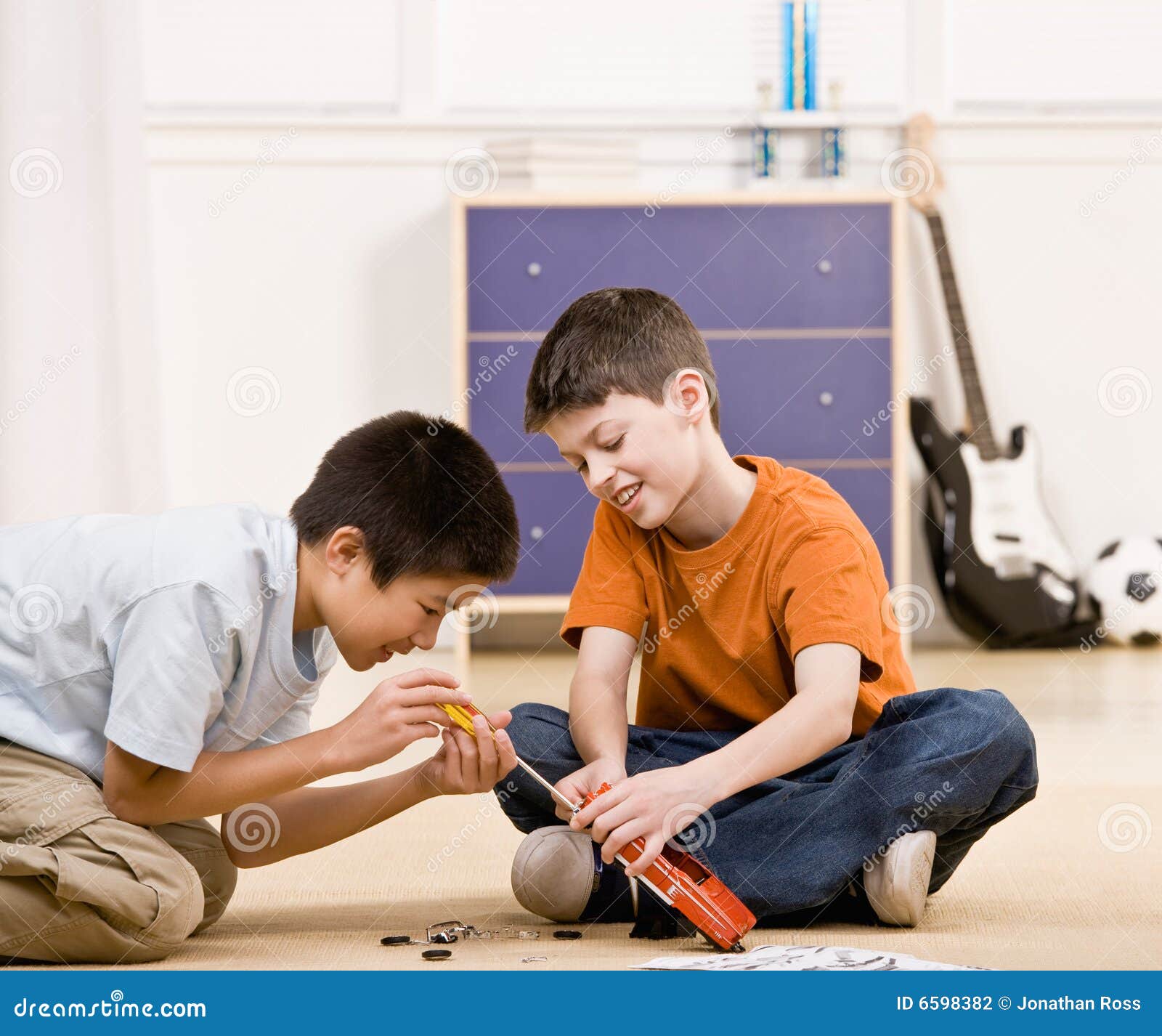 Boy Helping Friend Fix Broken Toy Stock Photo - Image of assisting ...