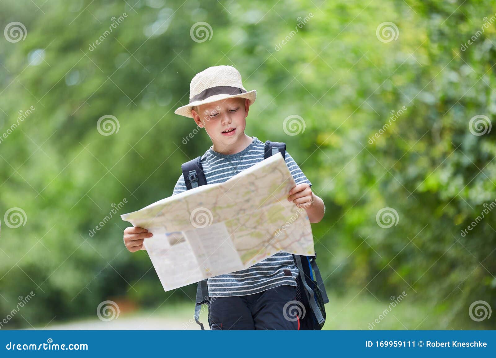 Boy on a hike looks on map stock image. Image of kids - 169959111
