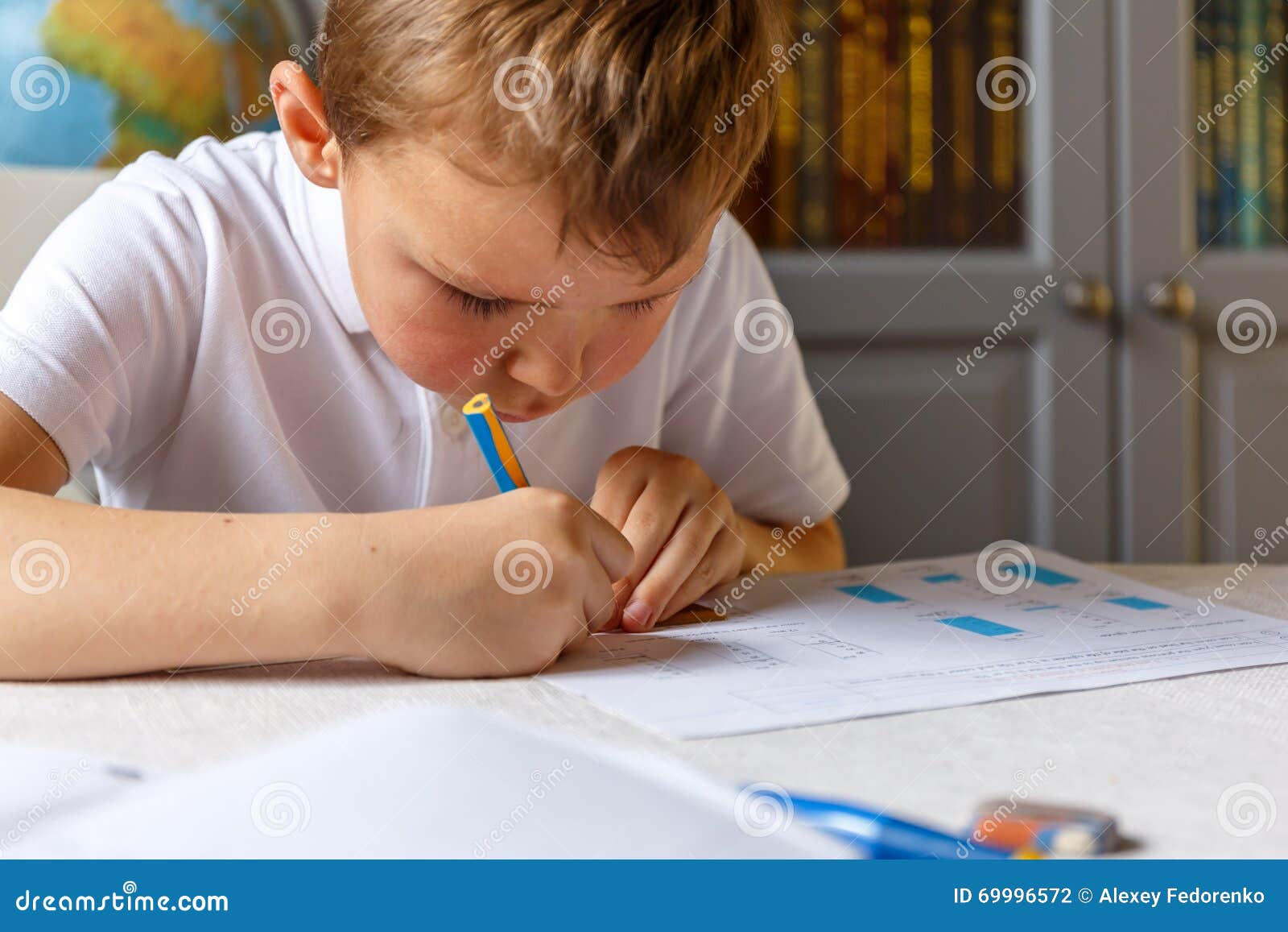 Boy at his homework stock photo. Image of reading, globe - 69996572