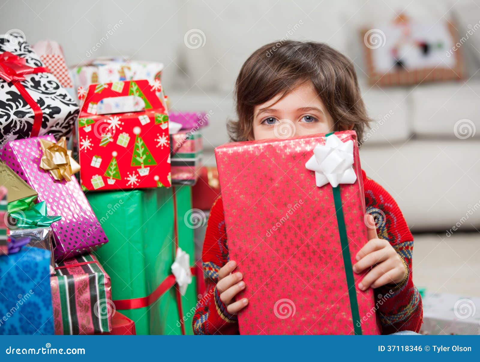 Boy Holding Christmas Gift in Front of Face Stock Photo - Image of ...