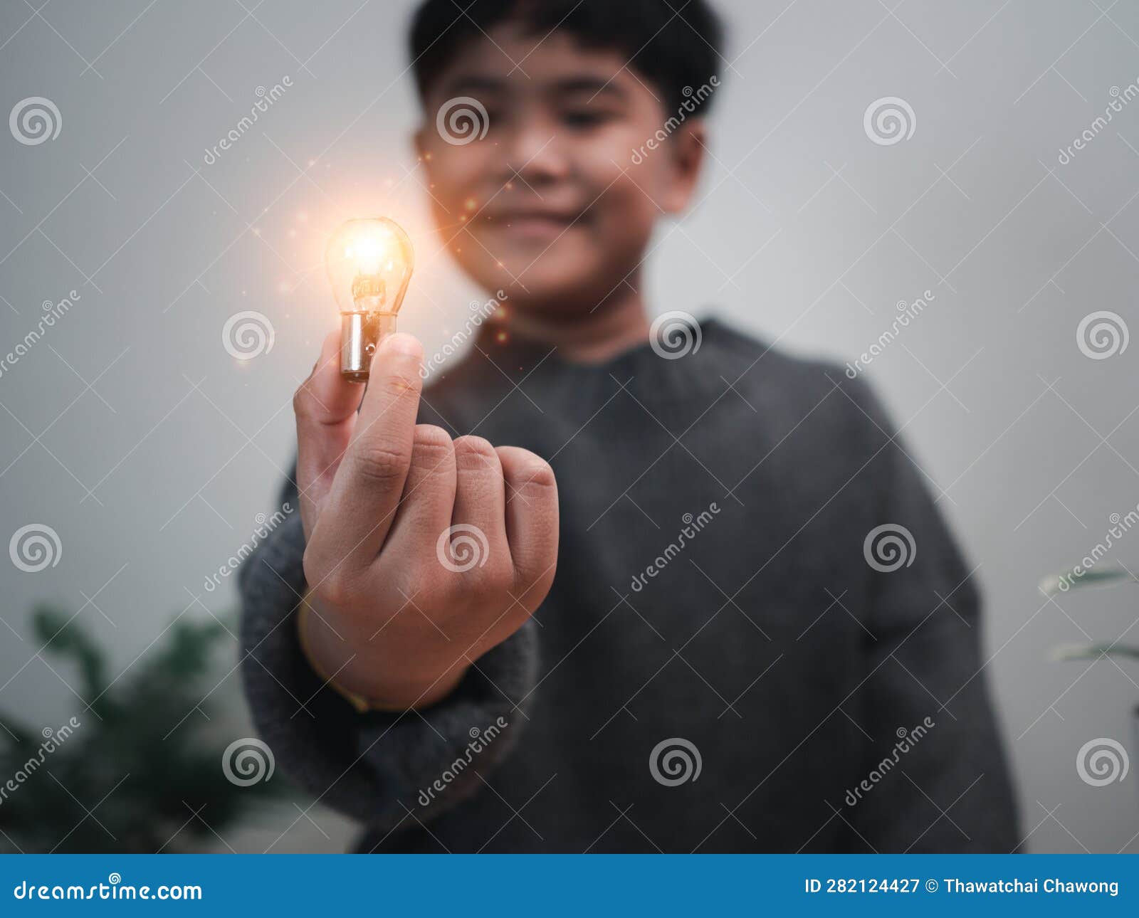 The Boy is Holding a Light Bulb. it Represents the Concept of Education ...