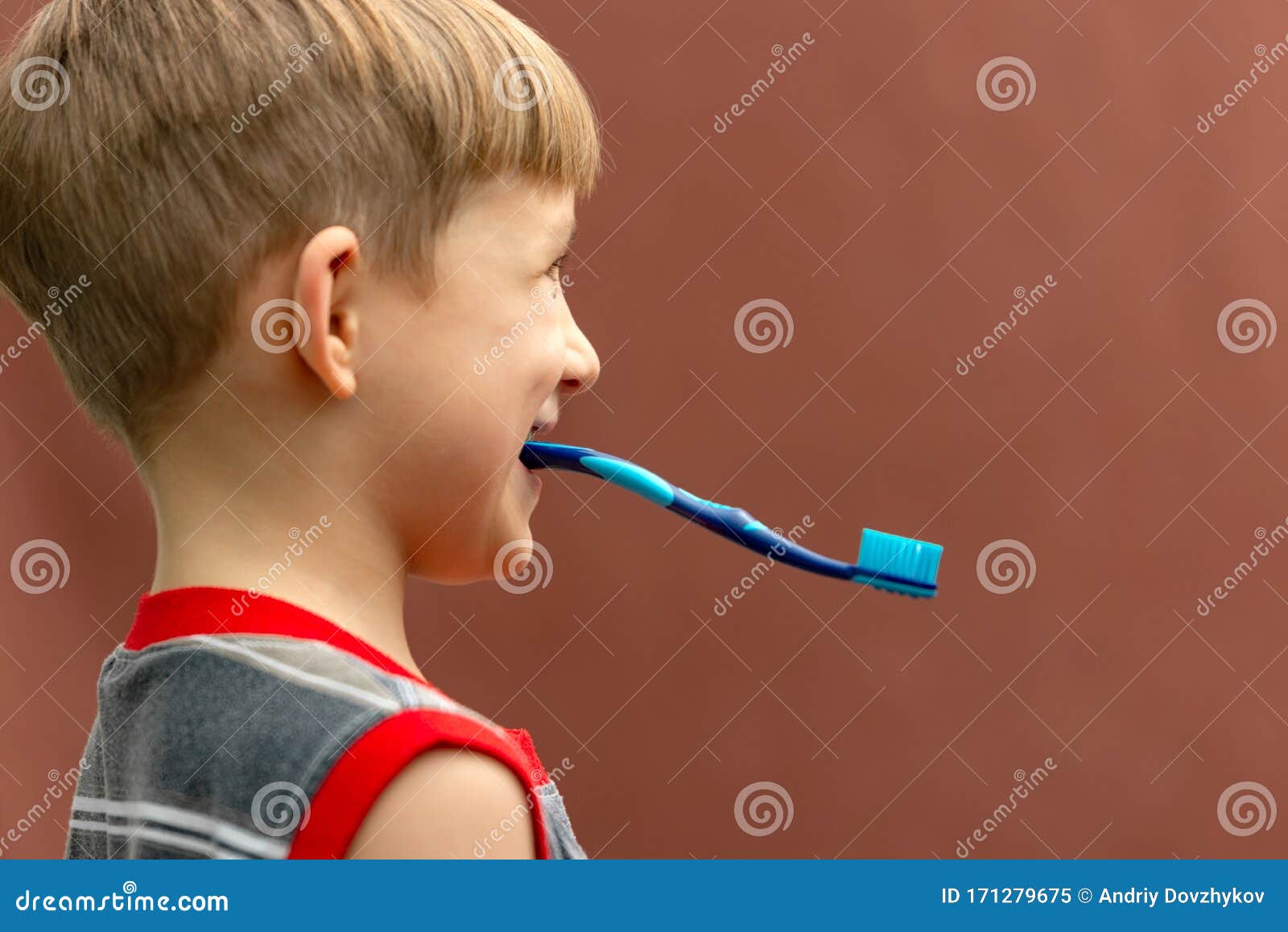 The Boy Holds the Toothbrush in His Teeth with the Reverse Side Stock ...