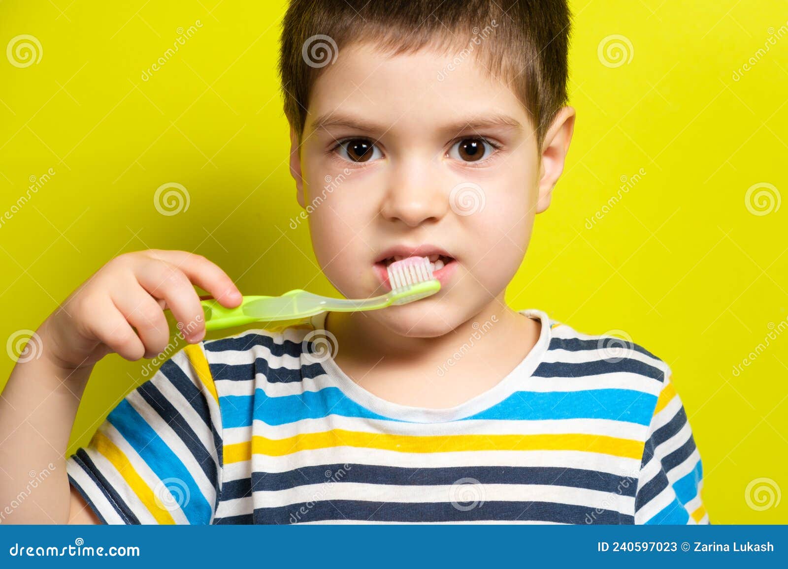 A Boy Holds a Toothbrush with Pink Toothpaste, Looking into the Camera ...