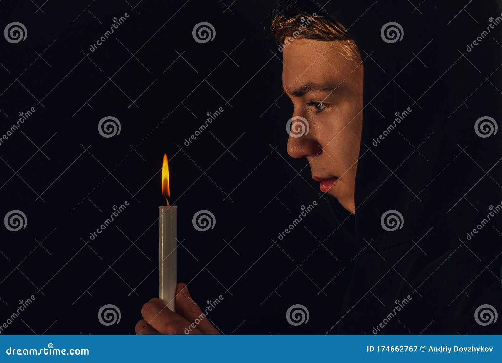 The Boy in the Hood Holds a Burning Candle in His Hand Stock Image ...