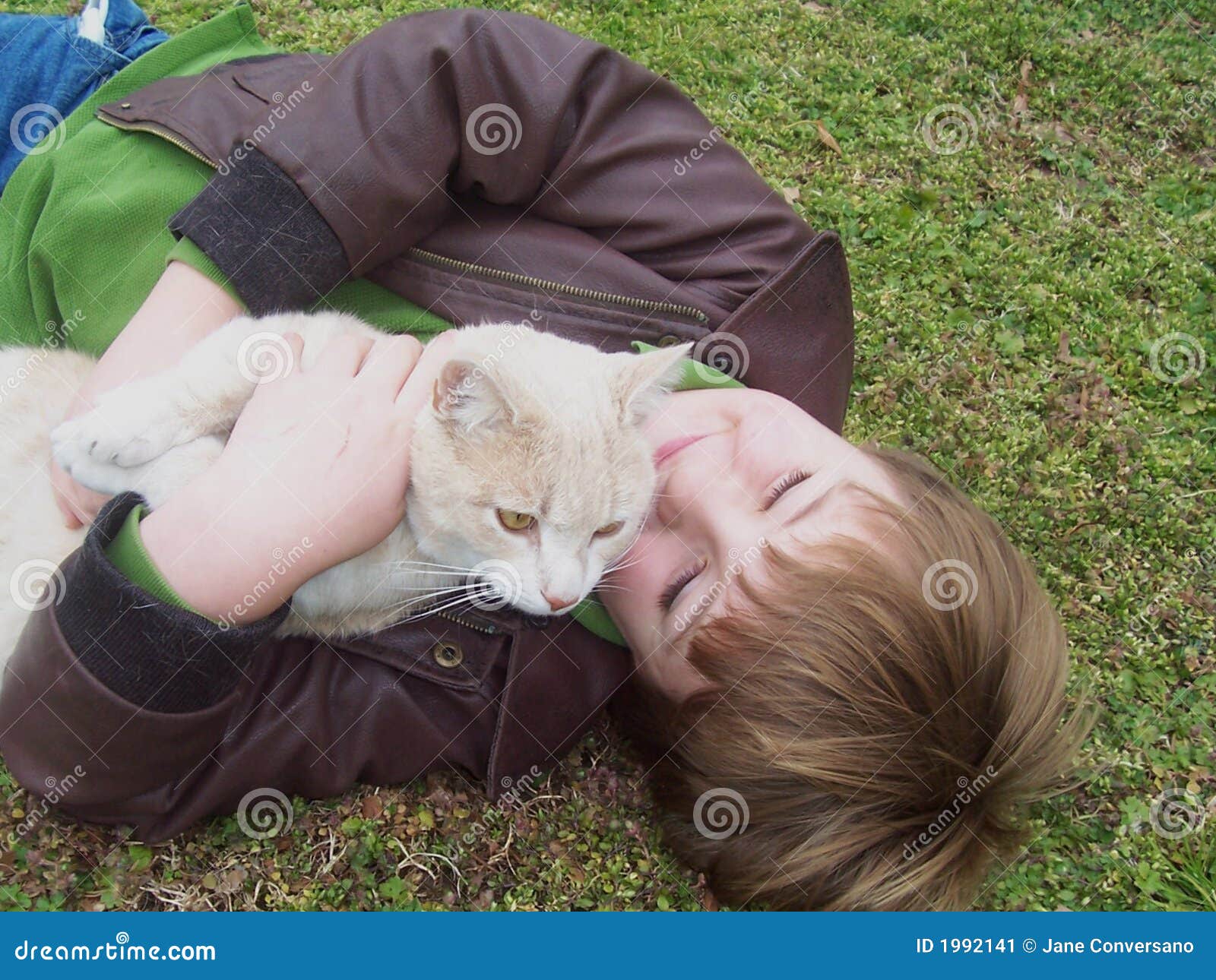 Boy hugging cat in field stock image. Image of green, jacket - 1992141