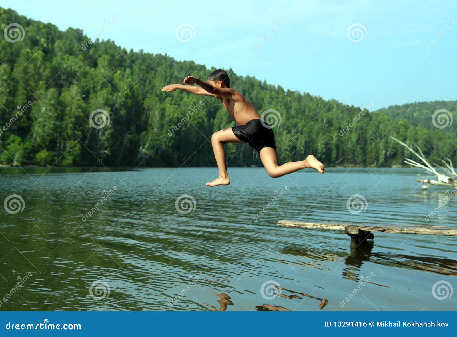 Boy jumping in lake stock photo. Image of diving, surface - 13291416