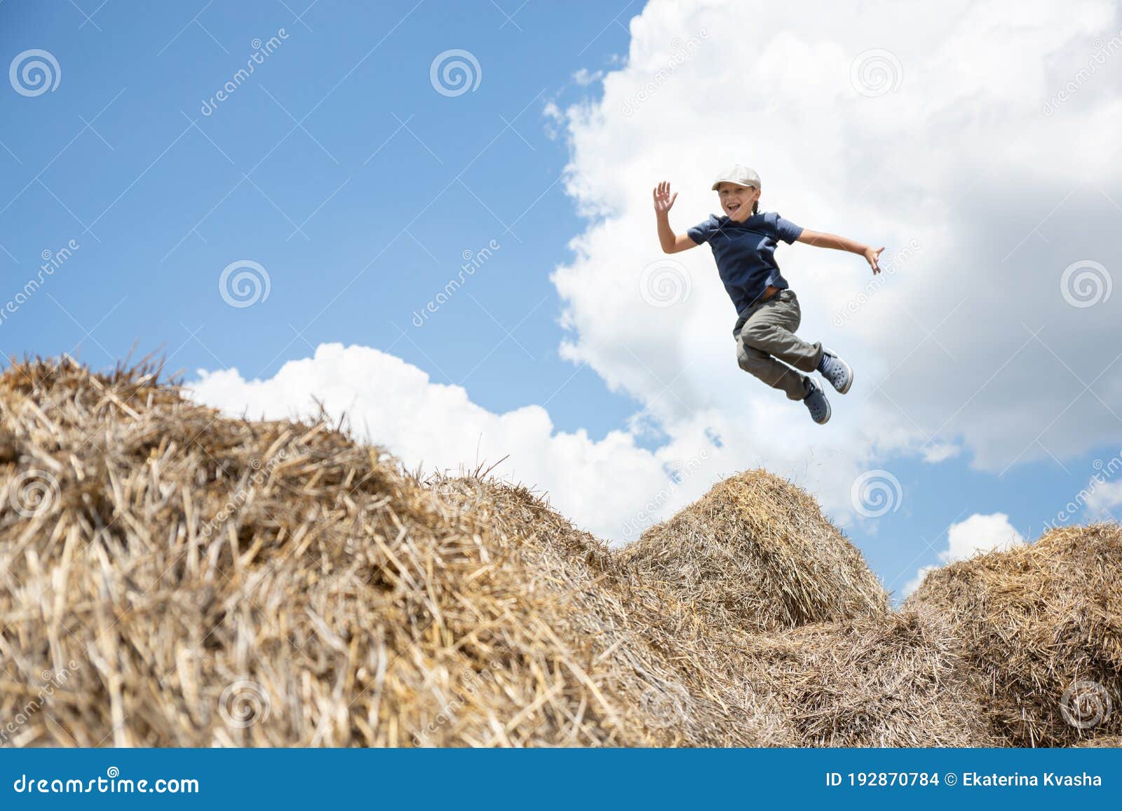 A Boy Jumps into a Haystack-a Figure Against the Sky Stock Photo ...