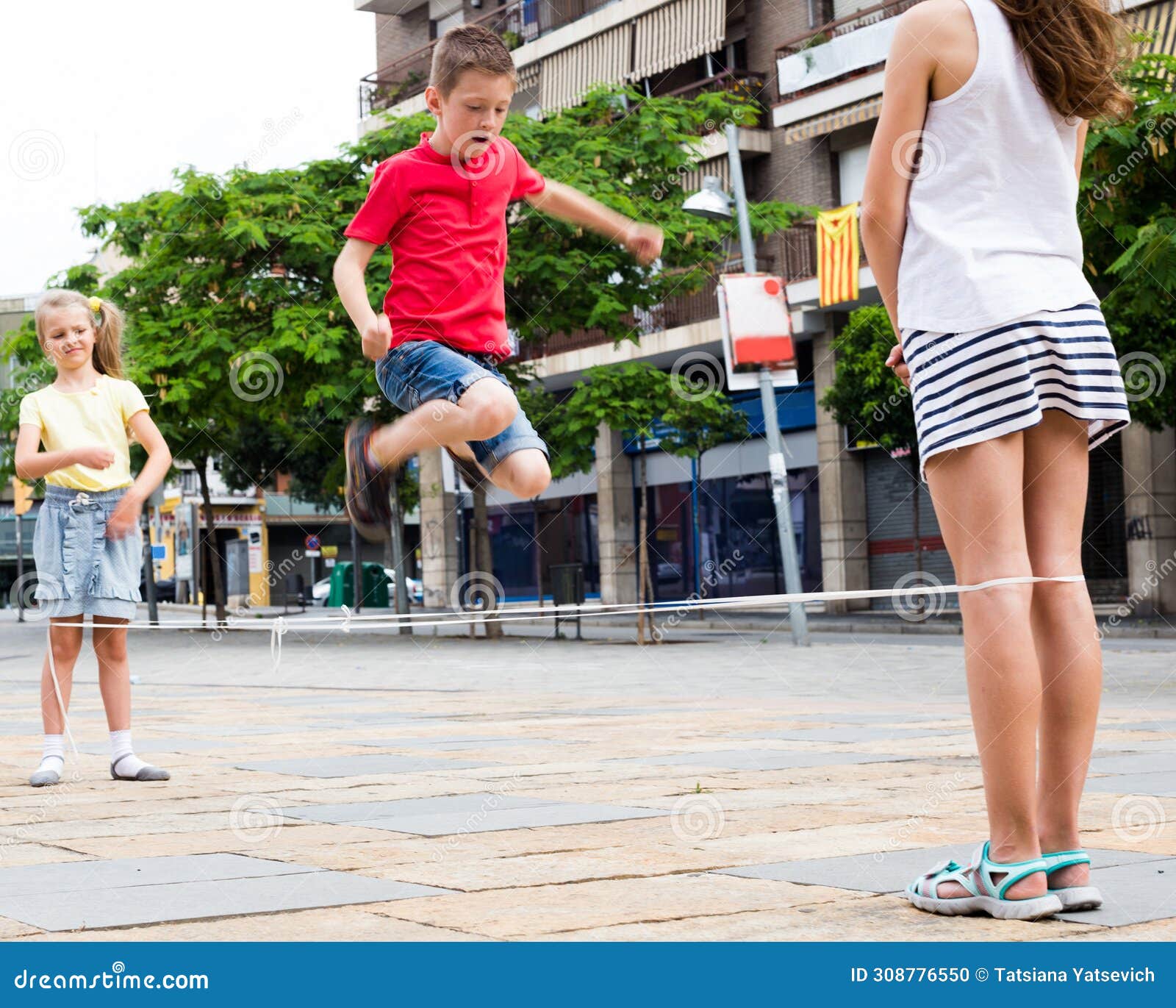 Boy Jumps Over the Rope on the Sidewalk in the City in Summer Stock ...