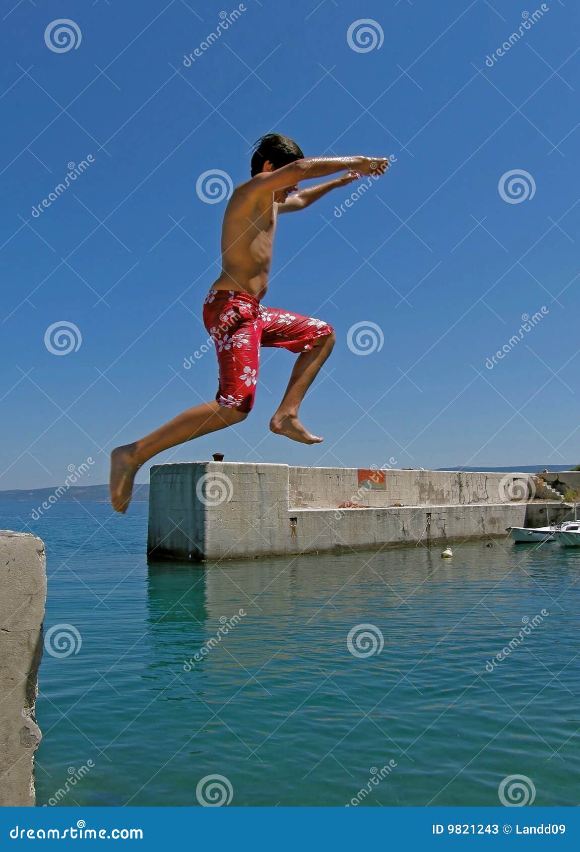Boy jumping in sea stock image. Image of attractive, clothes - 9821243