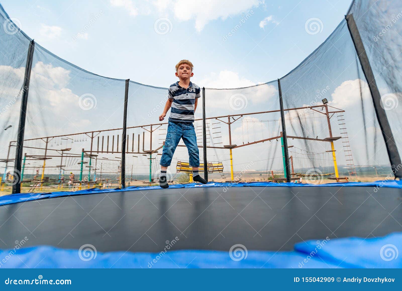 The Boy Jumps on a Trampoline in an Amusement Park, Performing Various ...