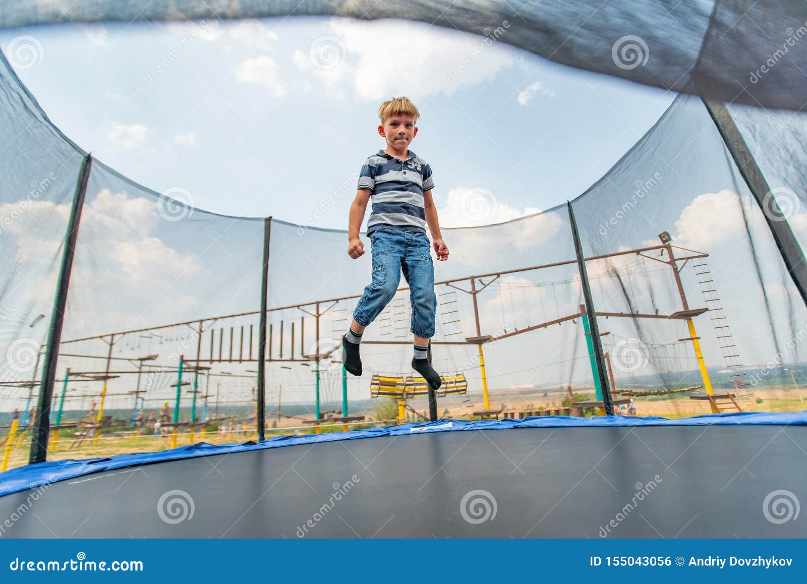 The Boy Jumps on a Trampoline in an Amusement Park, Performing Various ...