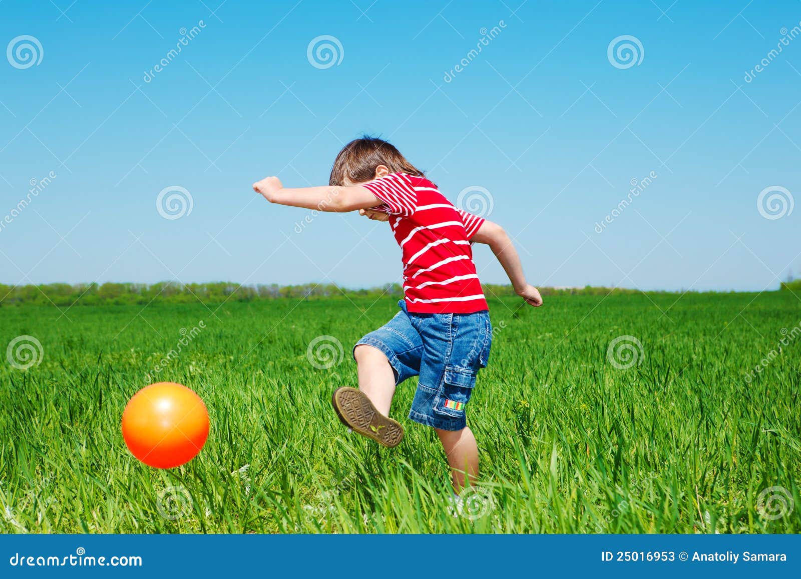 Boy kicking ball stock image. Image of outside, grass - 25016953