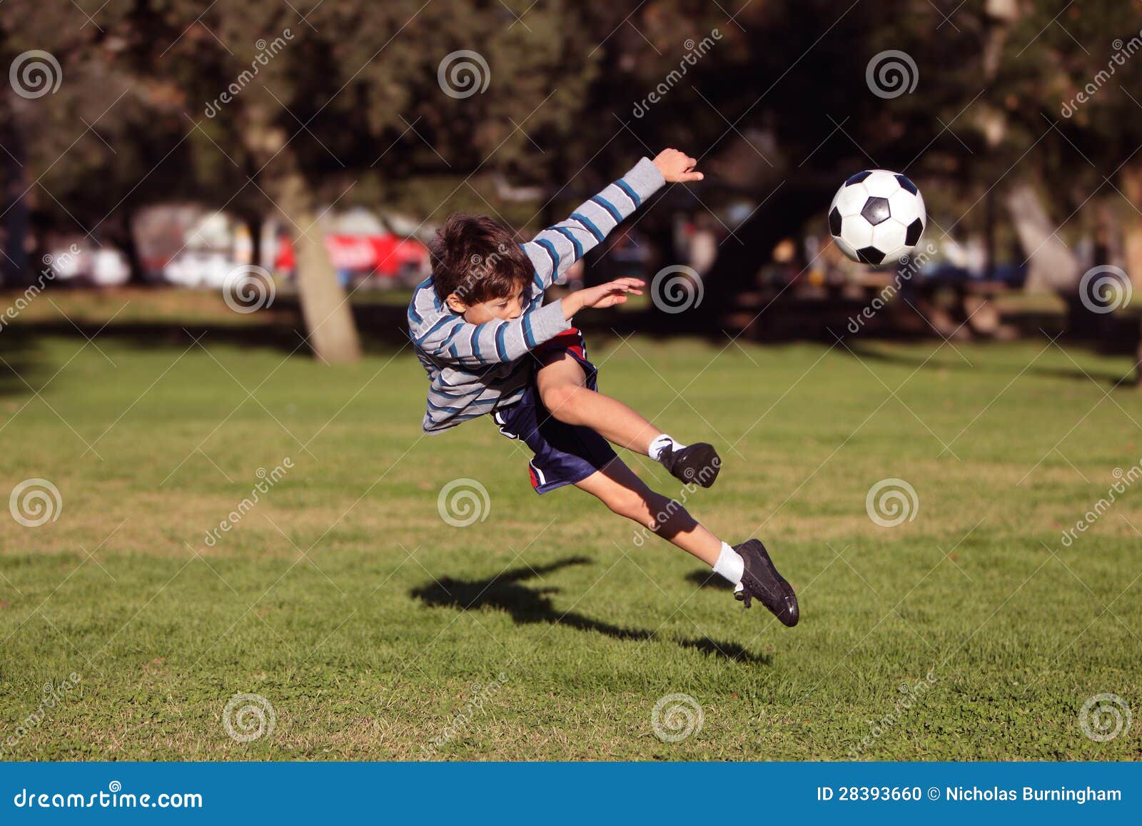 Boy kicking soccer ball stock photo. Image of jump, running - 28393660