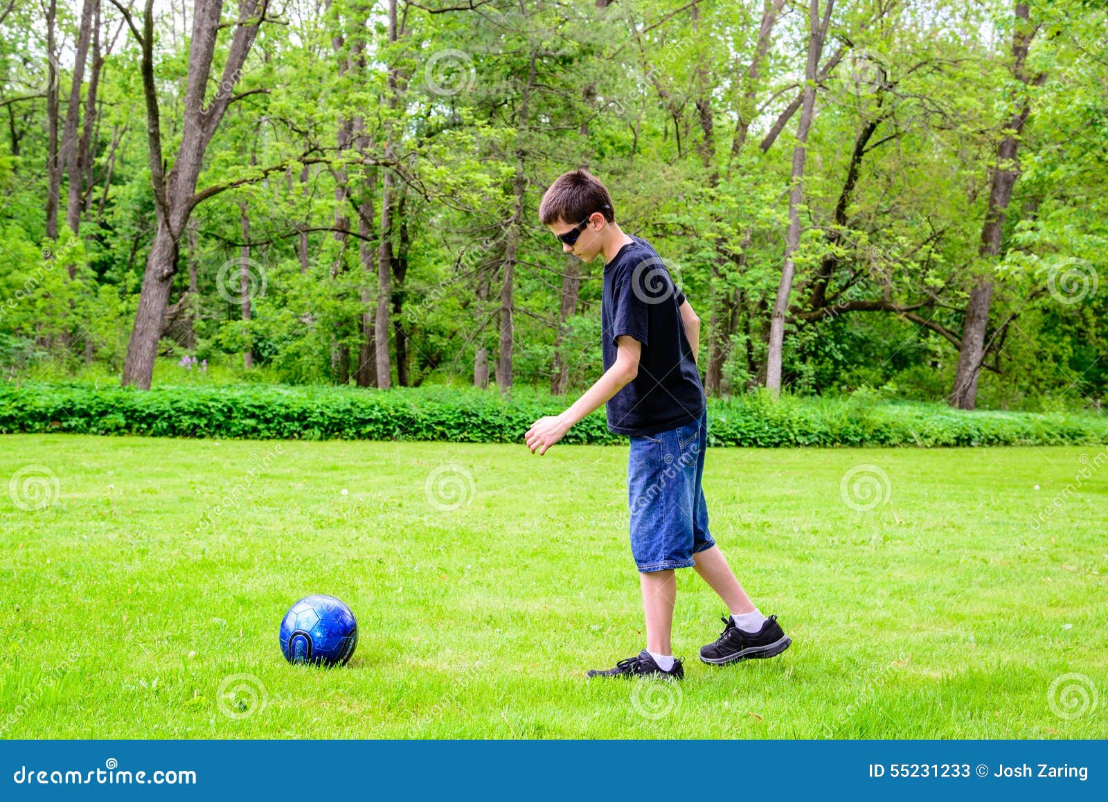 Boy Kicking Soccer Ball stock image. Image of sunshine - 55231233