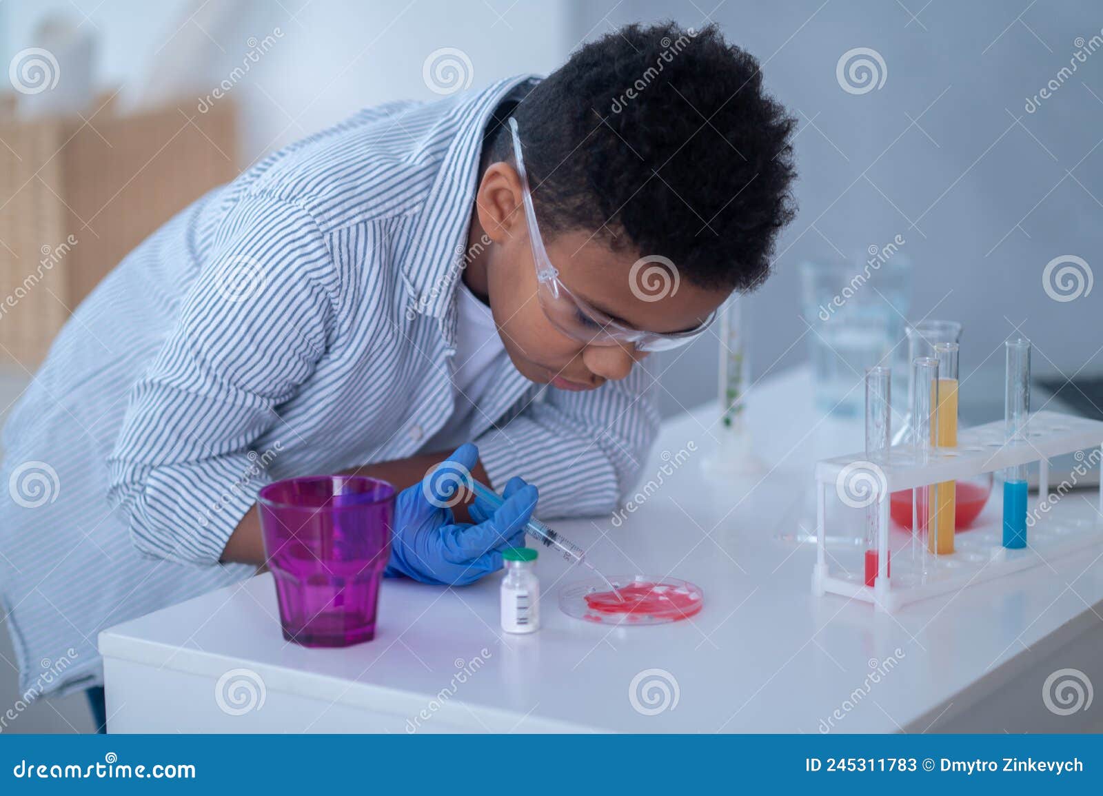 A Boy in a Lab Coat Working with Test Tubes and Looking Involved Stock ...