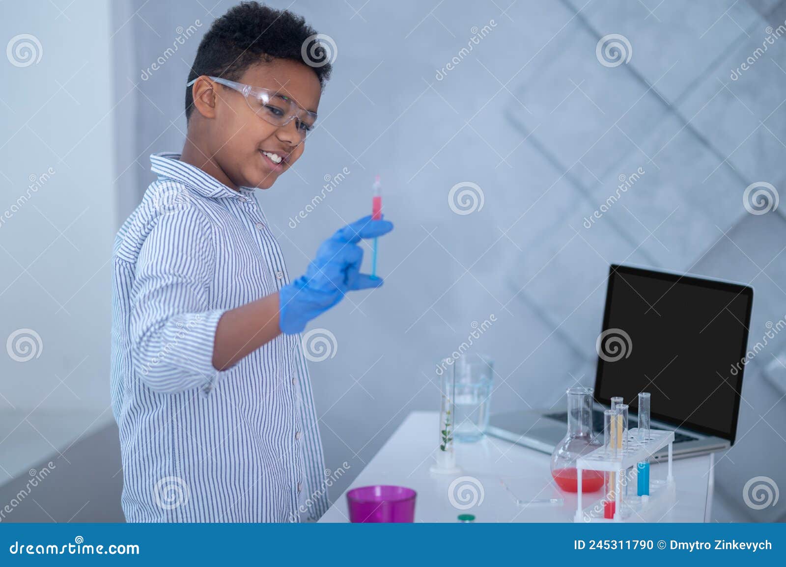A Boy in a Lab Coat Working with Test Tubes and Looking Involved Stock ...