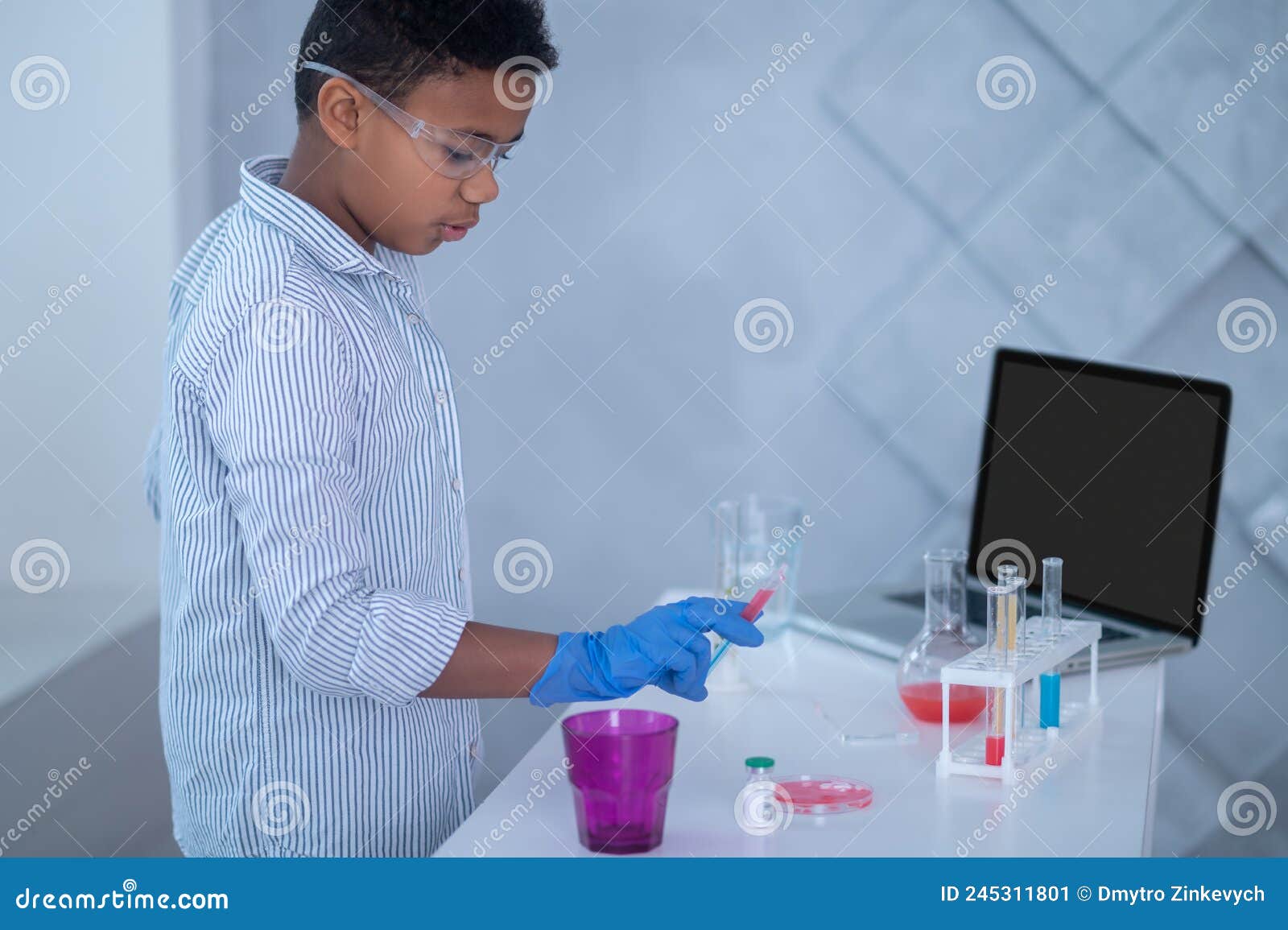 A Boy in a Lab Coat Working with Test Tubes and Looking Involved Stock ...
