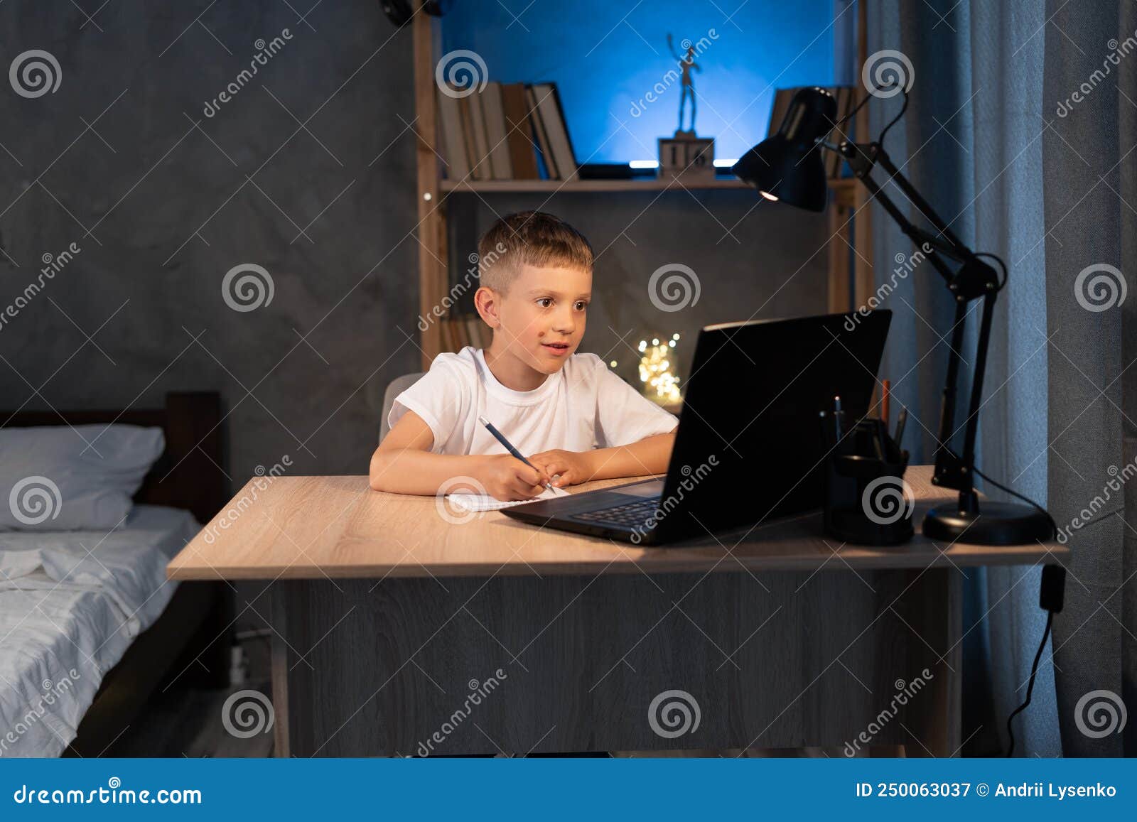 Boy with Laptop Doing Homework at Table in Evening Stock Image - Image ...