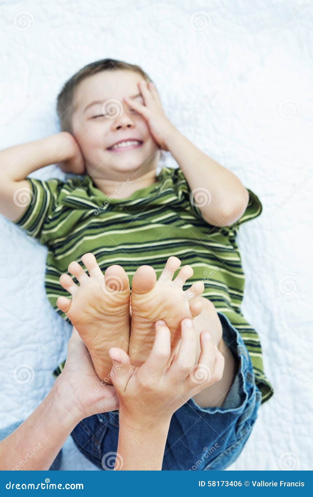 Boy laughing feet tickling stock photo. Image of hands - 58173406