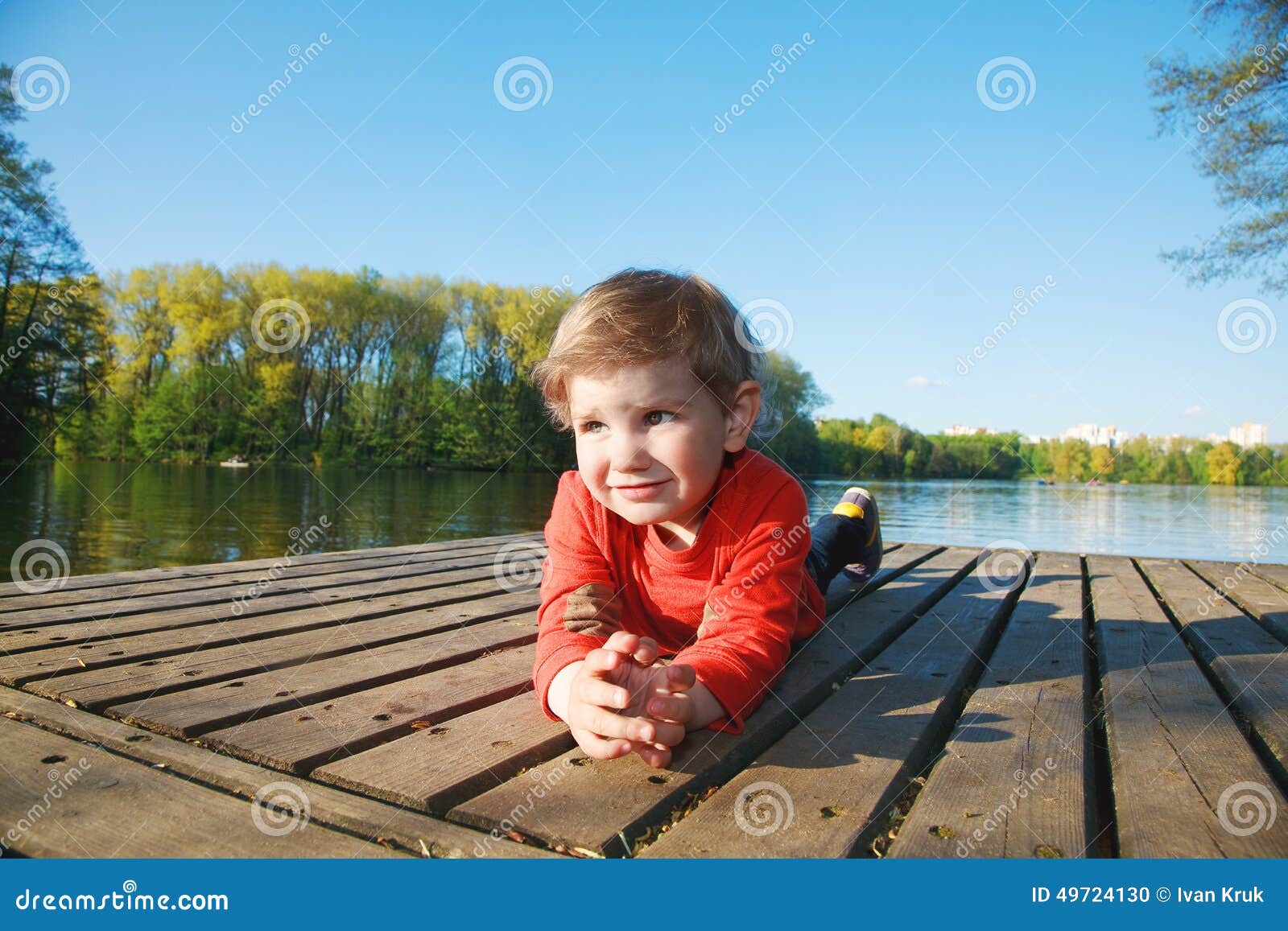 Boy laying on dock at lake stock photo. Image of leisure - 49724130